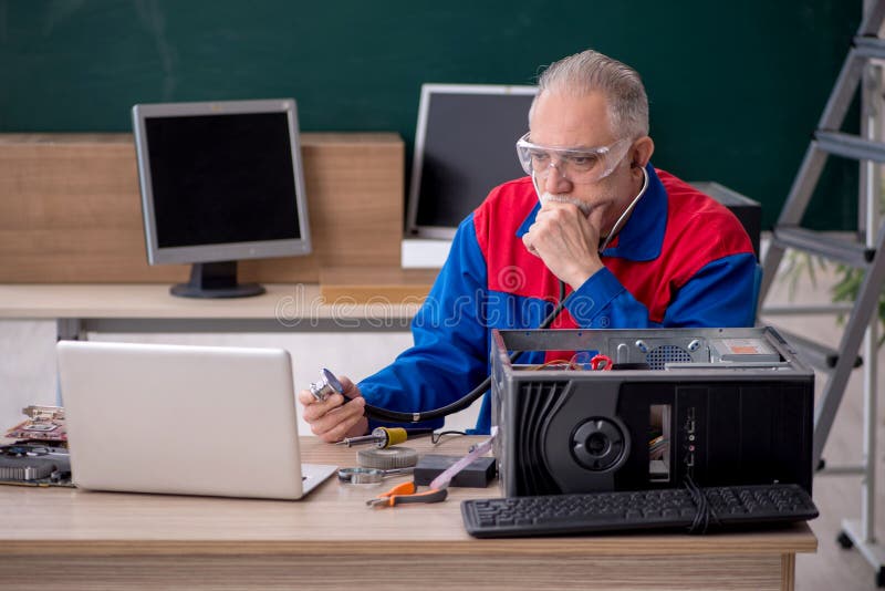 Old Repairman Repairing Computers in the Classroom Stock Photo - Image ...