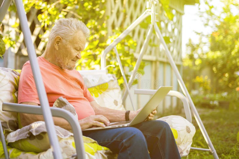 Old Retired Man Working on Computer in Summer Cottage Garden Stock ...