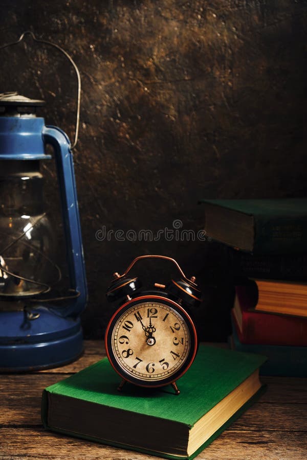 Old Retro Alarm Clock in Rustic Interior with Books and Kerosene Lamp ...