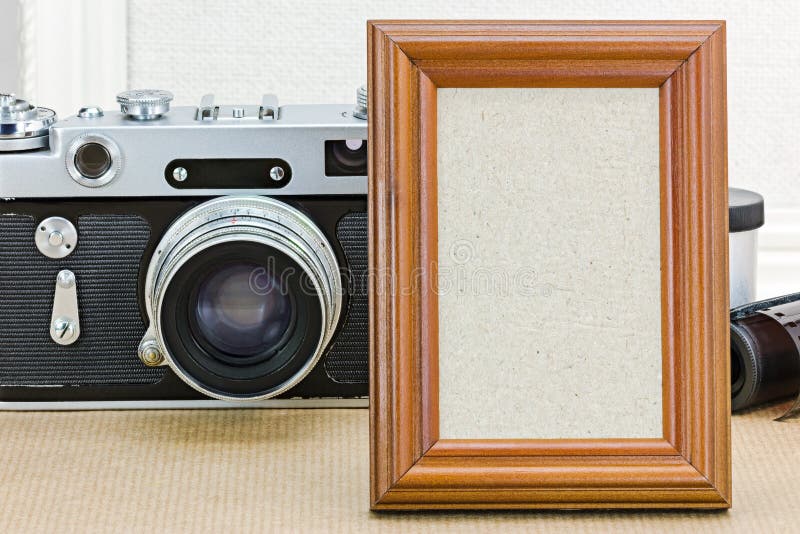 Old Retro Camera and Empty Wooden Photo Frame on Brown Paper Background ...