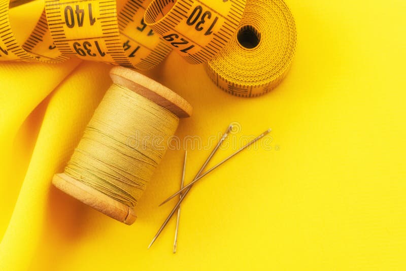 Old Retro Sewing Accessories Lie on a Yellow Fabric. Needle and Thread ...