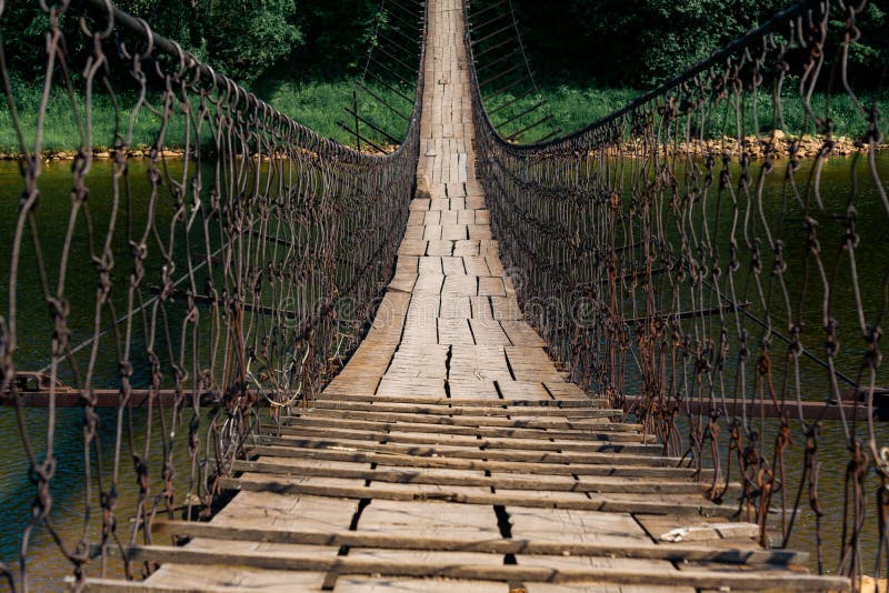 Old Rural Suspension Bridge Over the River Goes into Perspective Stock ...