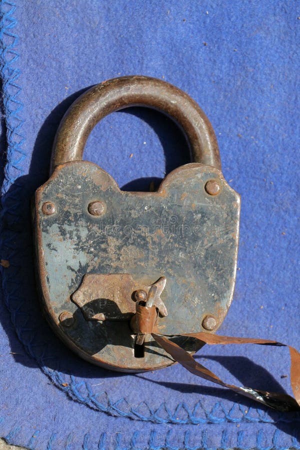The Old Rusted Metal Lock with a Key on a Blue Color Cloth Stock Photo ...