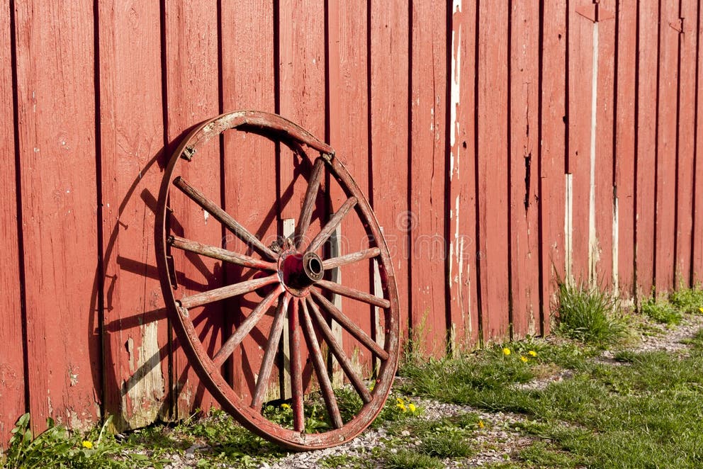 Old Rustic Wagon Wheel beside a Red Barn. Stock Image - Image of ...