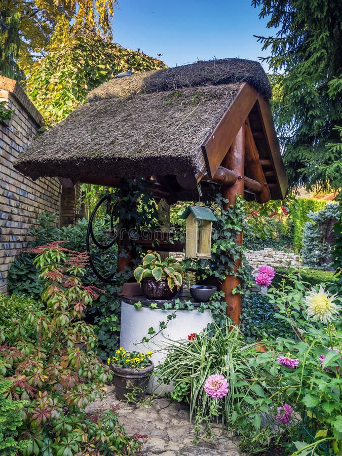 Rustic Garden Well With Stone Well Stock Photo - Image of plants ...