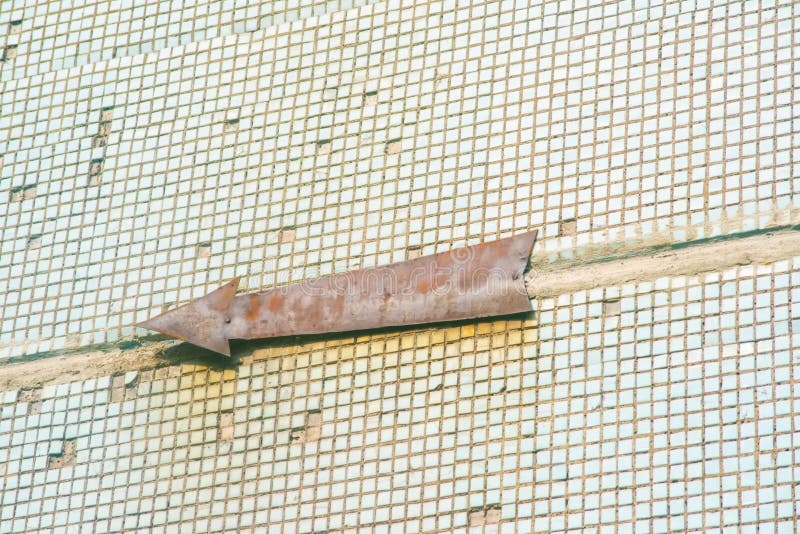 An Old and Rusty Arrow Pointer on the Panel Wall of the House Stock ...