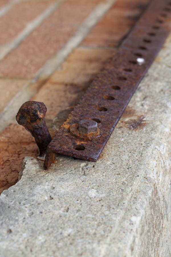 An Old Rusty Bolt and Metal Angle Iron Section on Broken Concrete Stock ...