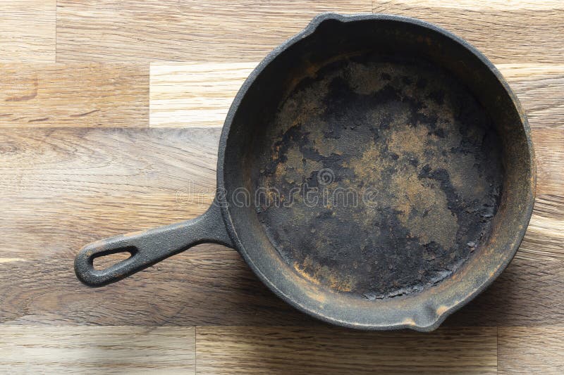 Old Rusty Cast Iron Frying Pan Background. on a Wooden Cutting Board ...
