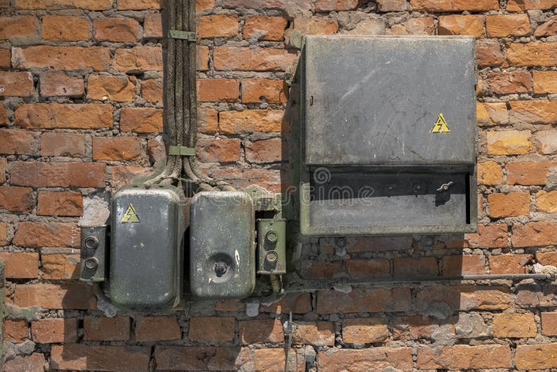 Old Rusty Electrical Panel with Buttons and Wires on a Ragged Red Brick ...