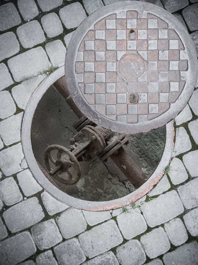 An Old Rusty Pipe at the Bottom of an Open Sewer Manhole on the ...
