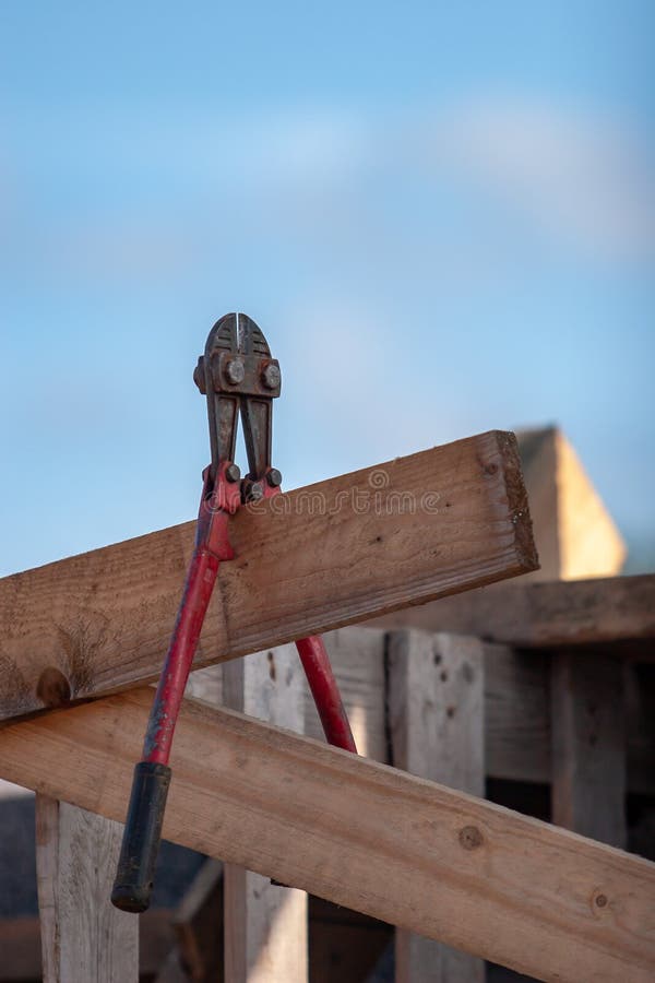 Old Rusty Red Bolt Cutter Hangs on a Construction Board. Stock Photo ...