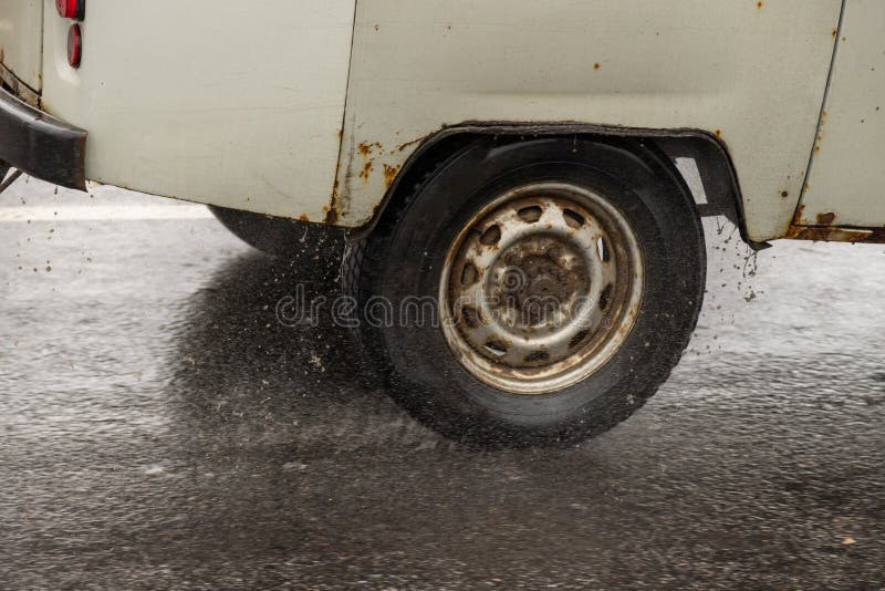 Old Rusty Soviet Minivan Driving on the Wet Asphalt Road during Heavy ...