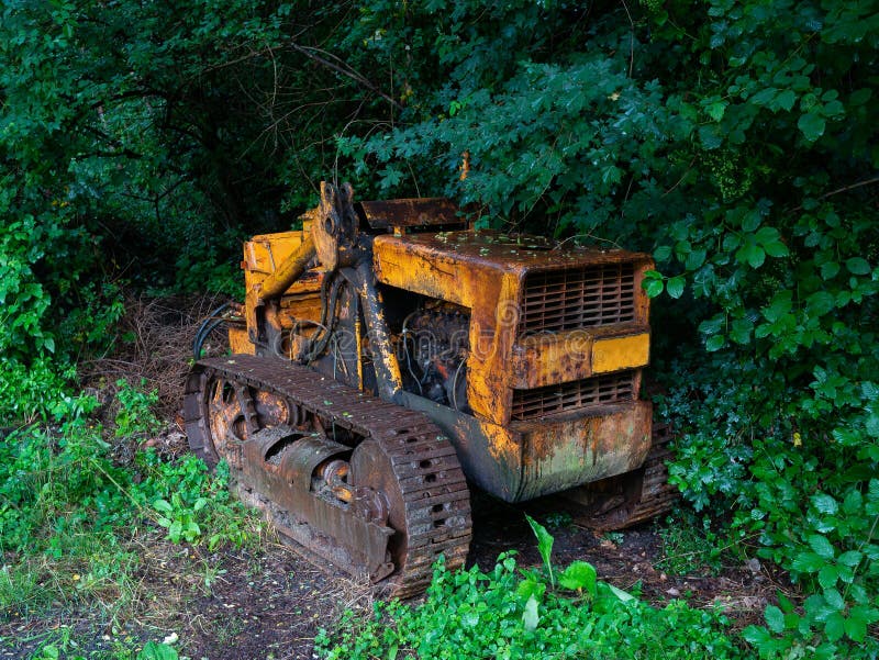Old Rusty Track Tractor Abandoned and Surrounded by Vegetation Stock ...
