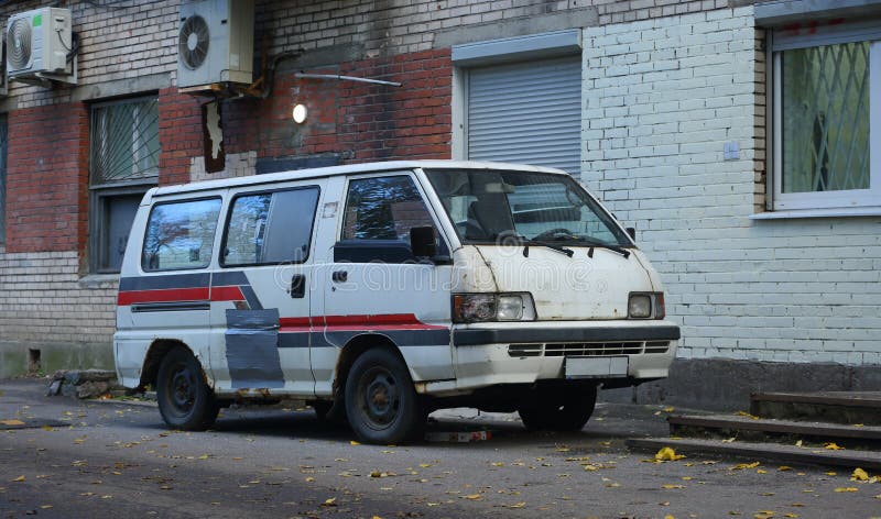 Old Rusty White Minivan Parked at a Gray House Walls Stock Image ...