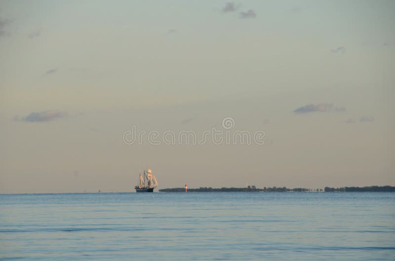 Old Sail Ship with Full Sails Pass a Distant Light House, Out in the ...