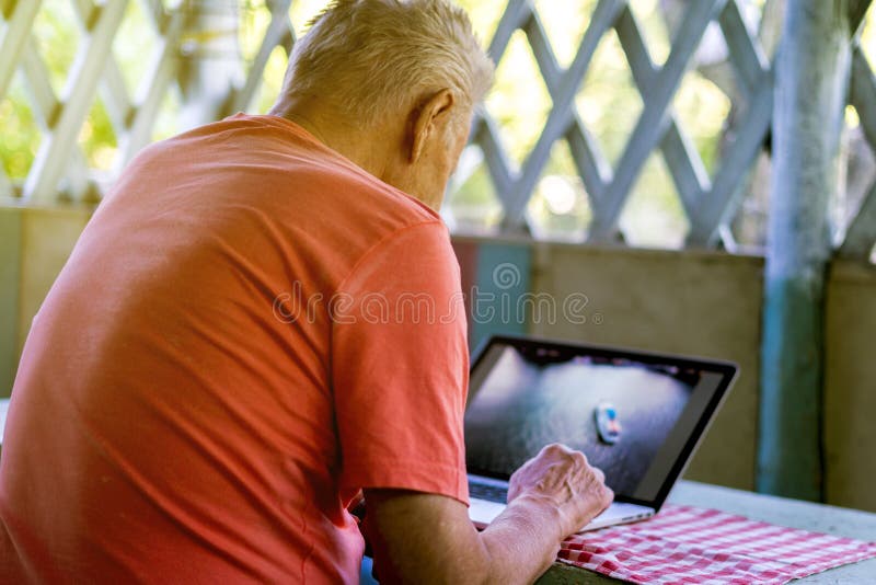 Old Senior Retired Man Working on a Laptop Computer in Summer Alcove ...