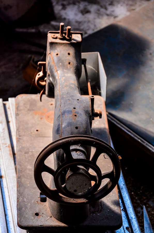 An Old Sewing Machine with a Rusty Wheel Sits on a Table Stock Image ...