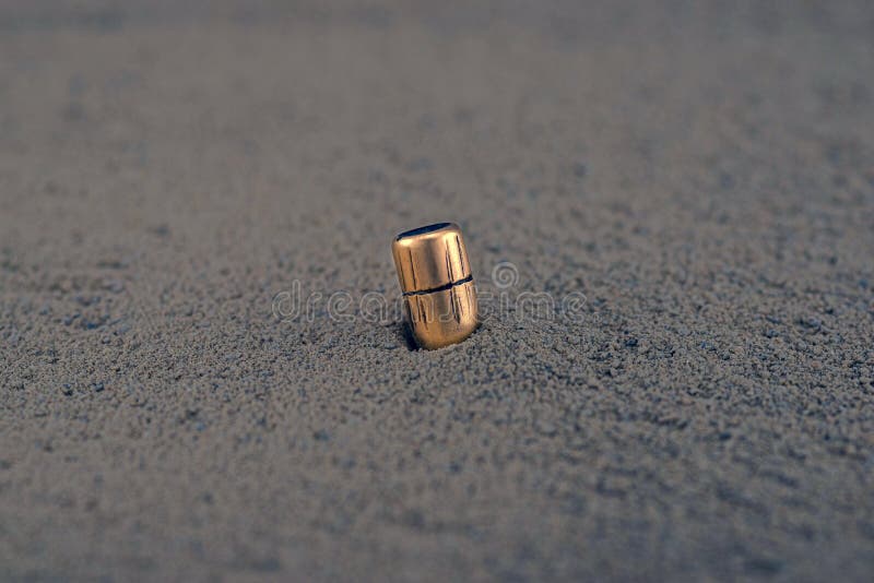 An Old Shiny Bullet Driven into the Sand Stock Image - Image of ...