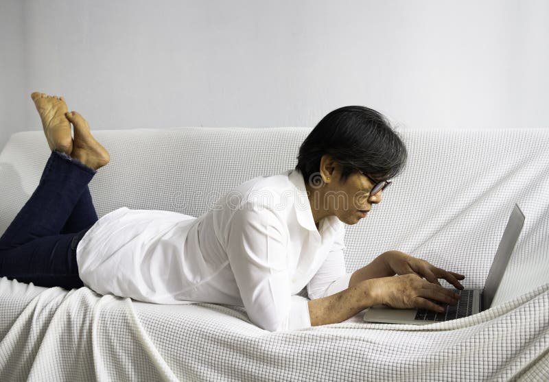 Old Smart Lady Laying Down on Sofa and Using Laptop Stock Image - Image ...