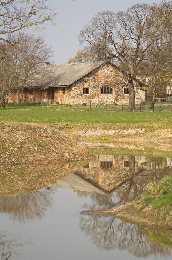 An Old Stone and Brick Building and a Reflection in the Pond Stock ...