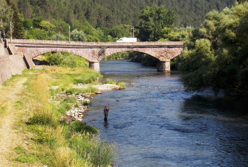 Old Stone Bridge and Fisherman in the River Stock Image - Image of ...