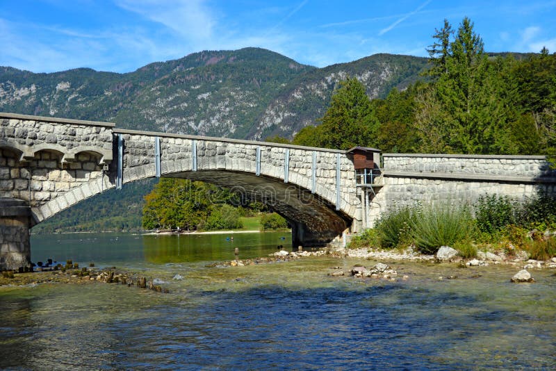 Old Stone Bridge Over a River Surrounded by Trees and Mountains Stock ...