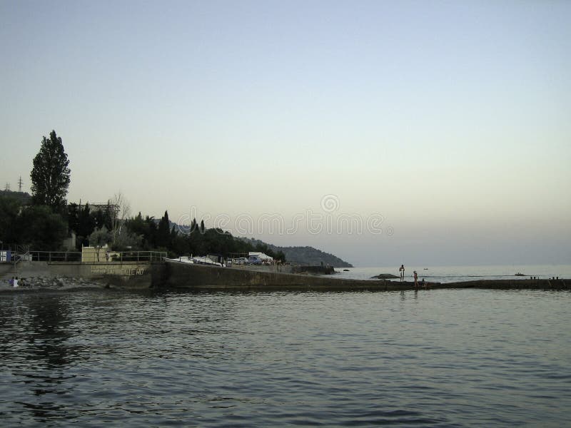 Old Stone Embankment Over a Rocky Beach at Sunset Stock Photo - Image ...