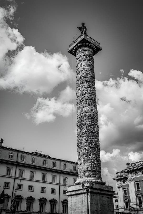 An Old Stone Pillar Stands on the Ground in Front of a White Building ...