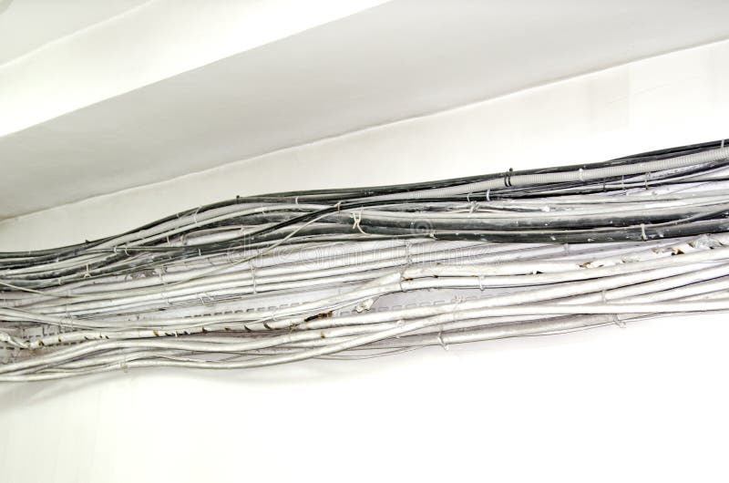 Old, Thick Cables Run Along a Wall in the Corridor of an Industrial ...