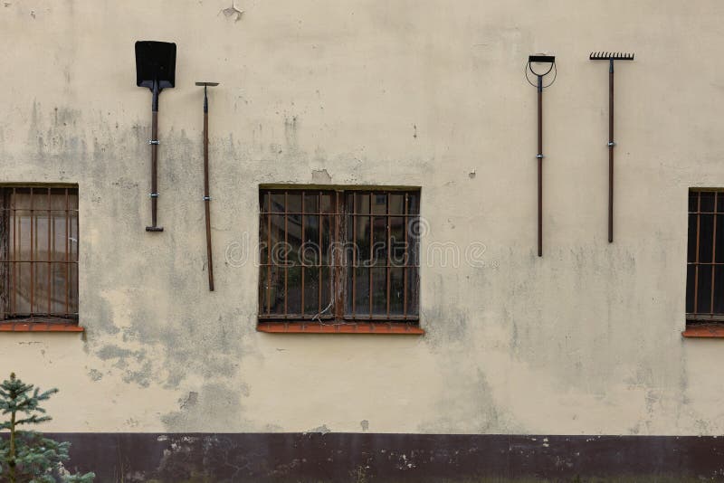 Old Tools Hanging on a Weathered Building Wall with Barred Windows ...
