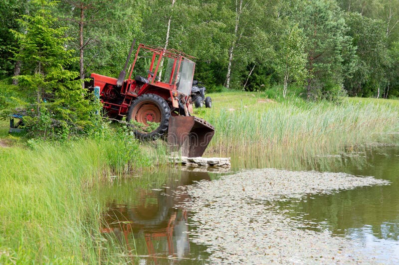 Old Tractor in Danger of Falling and Slipping in Lake and Overturn ...