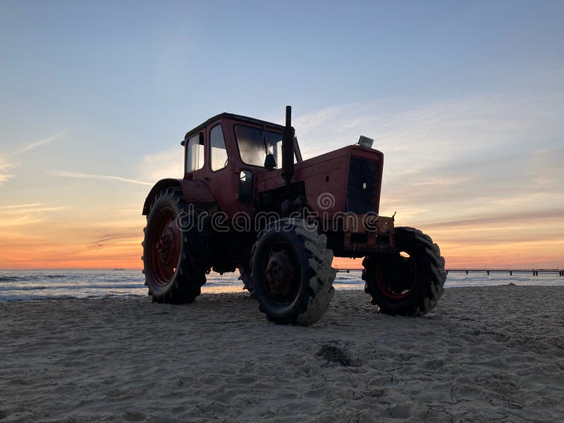An Old Tractor Sitting in the Sand on the Beach at Sunset Stock Image ...