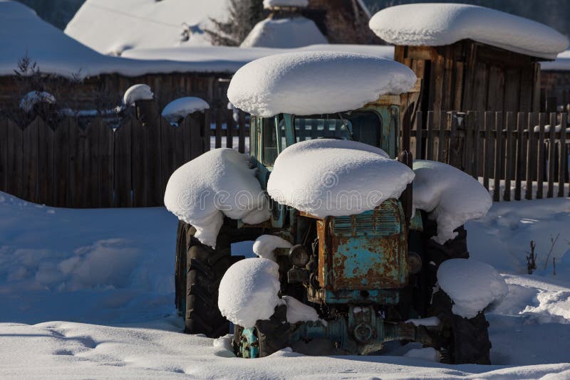 Old tractor under the snow stock photo. Image of difficult - 83633544