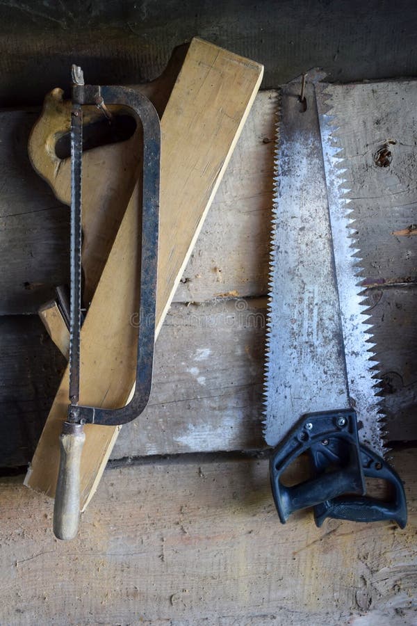 Old Various Hand Saws and a Plane for Woodworking Hang on the Wall in ...