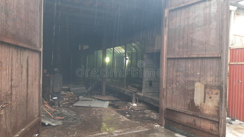 Old Warehouse Interior Showing Rain Entering through Open Doors in an ...
