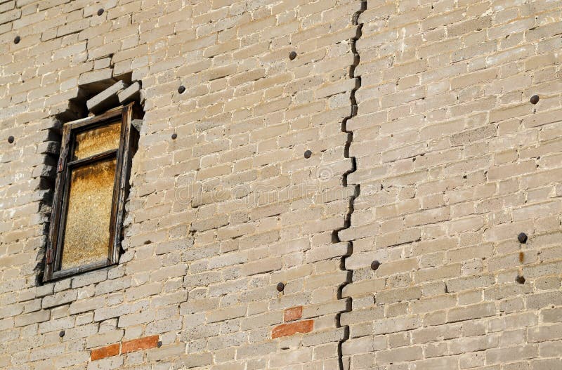 An Old Weathered Brick Wall with Big Crack in the Middle Fastened with ...