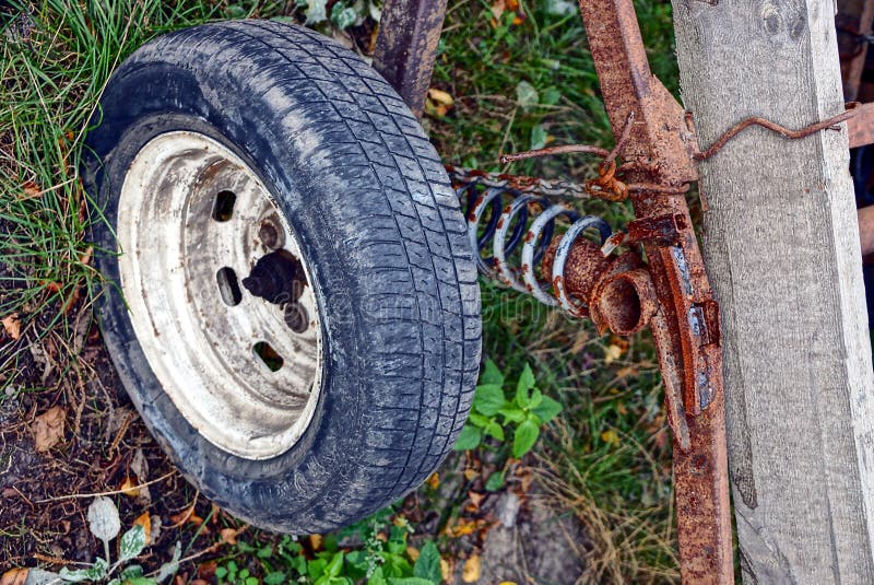 An Old Wheel with a Rusty Spring on a Cart in the Yard Stock Image ...