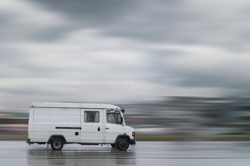 Old White Cargo Van is Driving Down the Street in the Rain with a ...