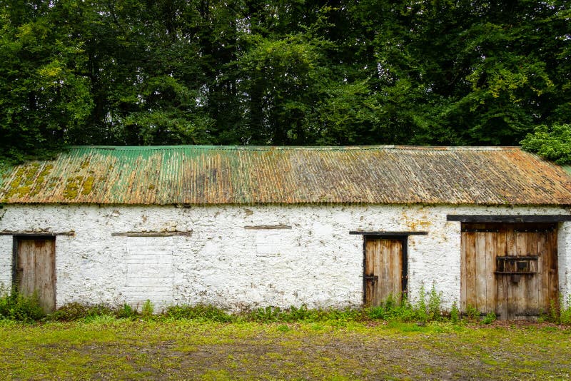 Old Whitewashed Building with Wooden Doors in the Forest Stock Image ...