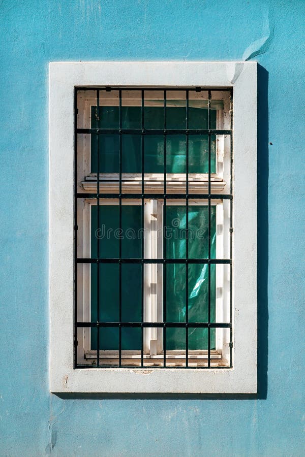 Old Window with Protective Metal Bars Cage and White Concrete Frame on ...
