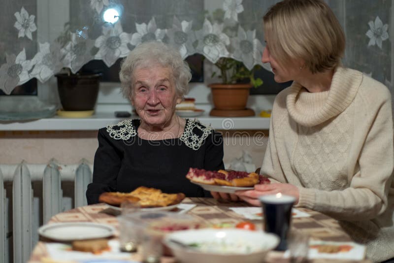 An Old Woman at the Dinner Table with Her Daughter. Stock Photo - Image ...