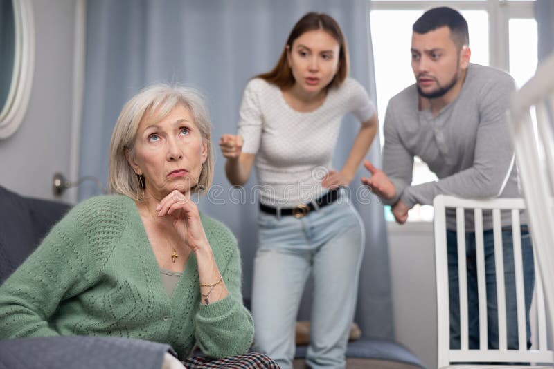 Old Woman Ignoring Her Daughter And Son In Law Arguing With Her Stock