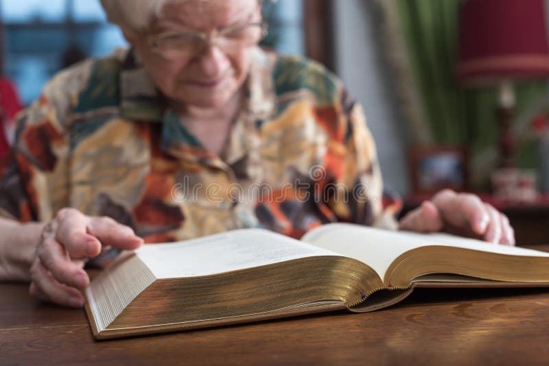 Old woman reading a book stock image. Image of retirement - 65958385