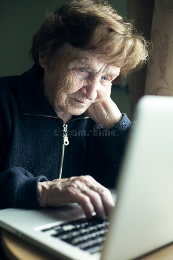 An Old Woman is Typing on a Laptop at Her Home. Stock Photo - Image of ...
