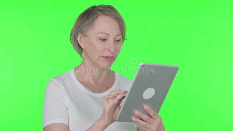 Old Woman Using Digital Tablet on Green Background Stock Photo - Image ...