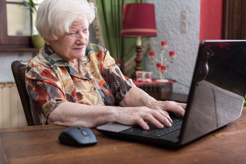 Old woman using a laptop stock photo. Image of retirement - 69121142