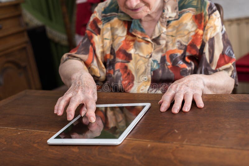 Old woman using a tablet stock photo. Image of retirement - 76887576