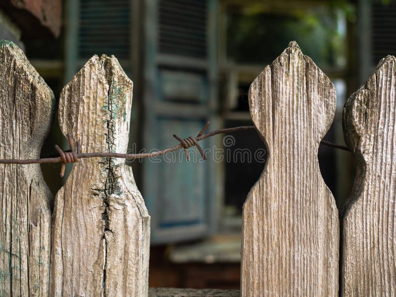 Old Wooden Fence with Barbed Wire. Rusty Barbed Wire on the Fence Stock ...