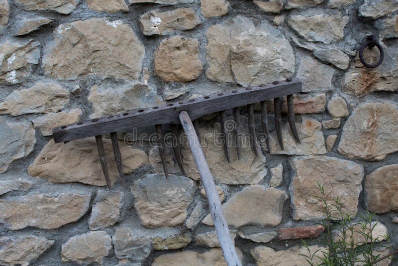 Old Wooden Rake Resting Against Old Stone Wall Stock Photo - Image of ...