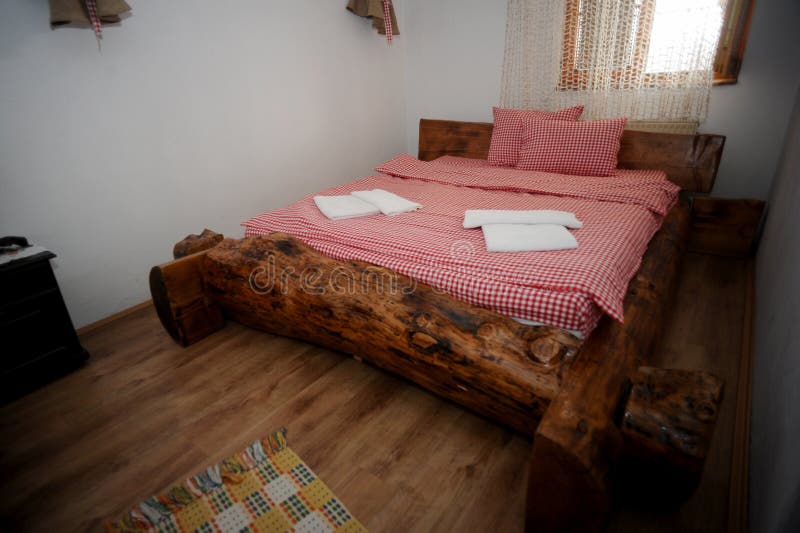 Old Wooden Rustic Bed with Red Sheets in the Cottage Stock Photo ...